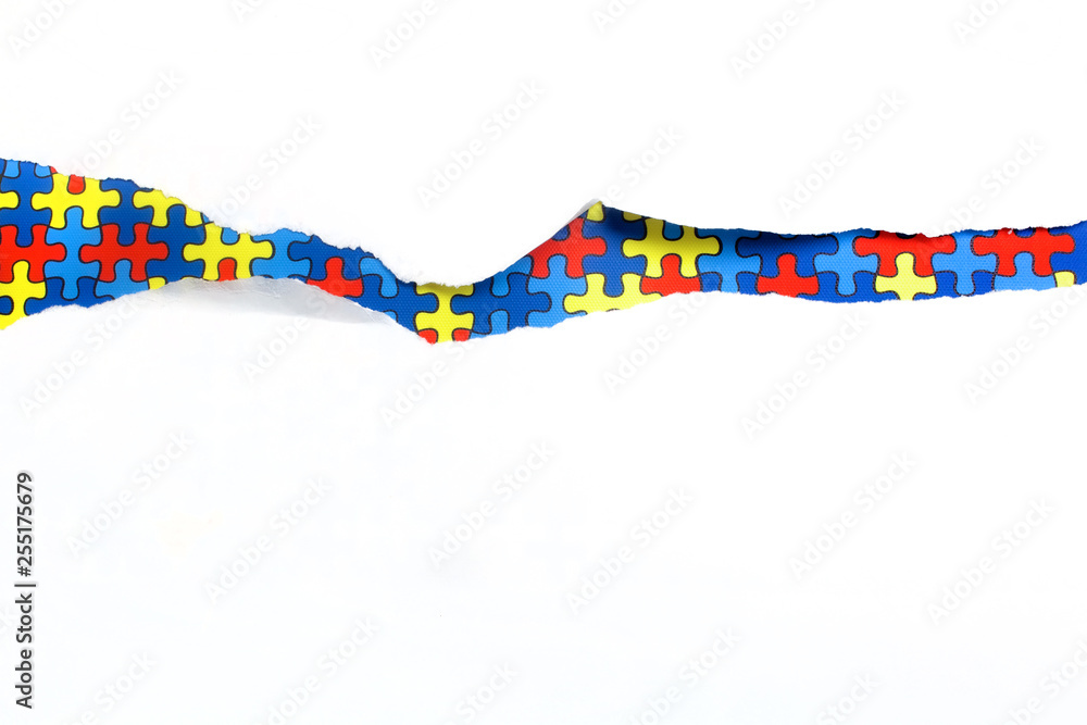 torn white paper on multicolored puzzle background. Cocept for autism ...
