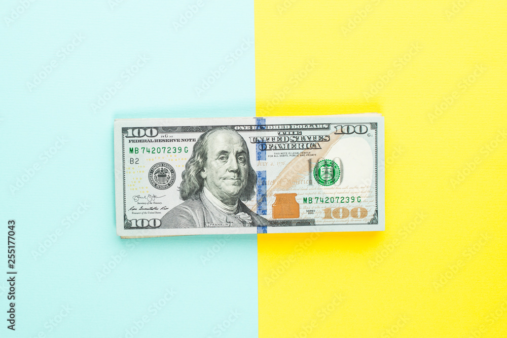 100 US dollar bill money cash on blue and yellow background. Heap of ...