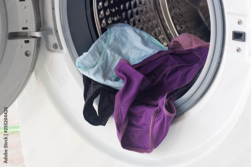 Washing machine full of dirty clothes. Stock Photo | Adobe Stock