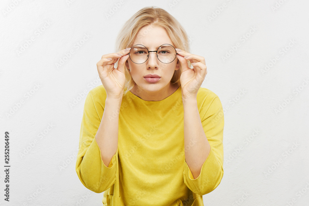 Portrait of a beautiful young woman with spectacles, looking curiously ...