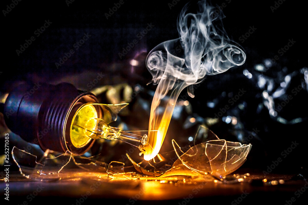 Amazing explosion of burning light bulb with splinters of broken glass ...