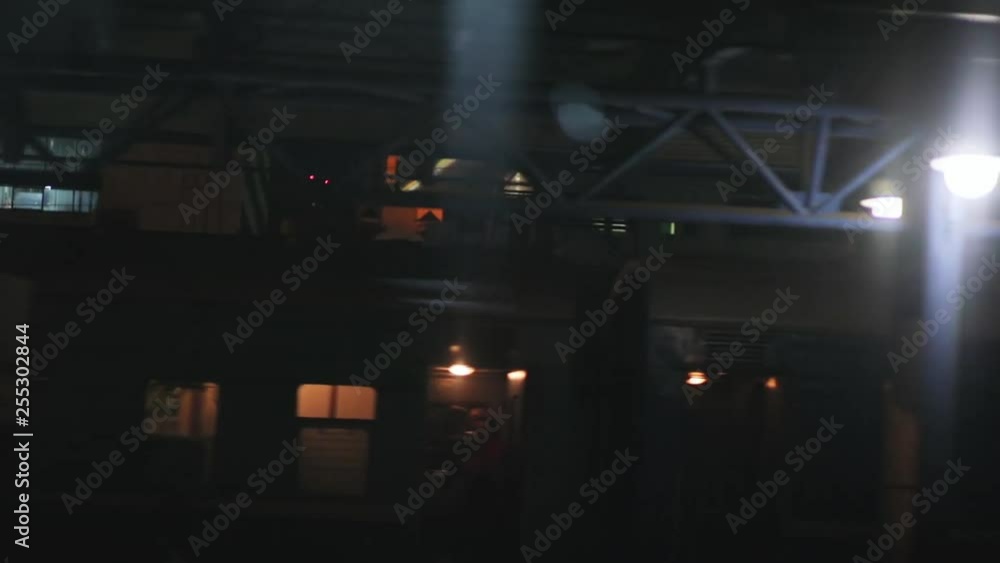 Driving away from the railway station on a modern train at night. View ...