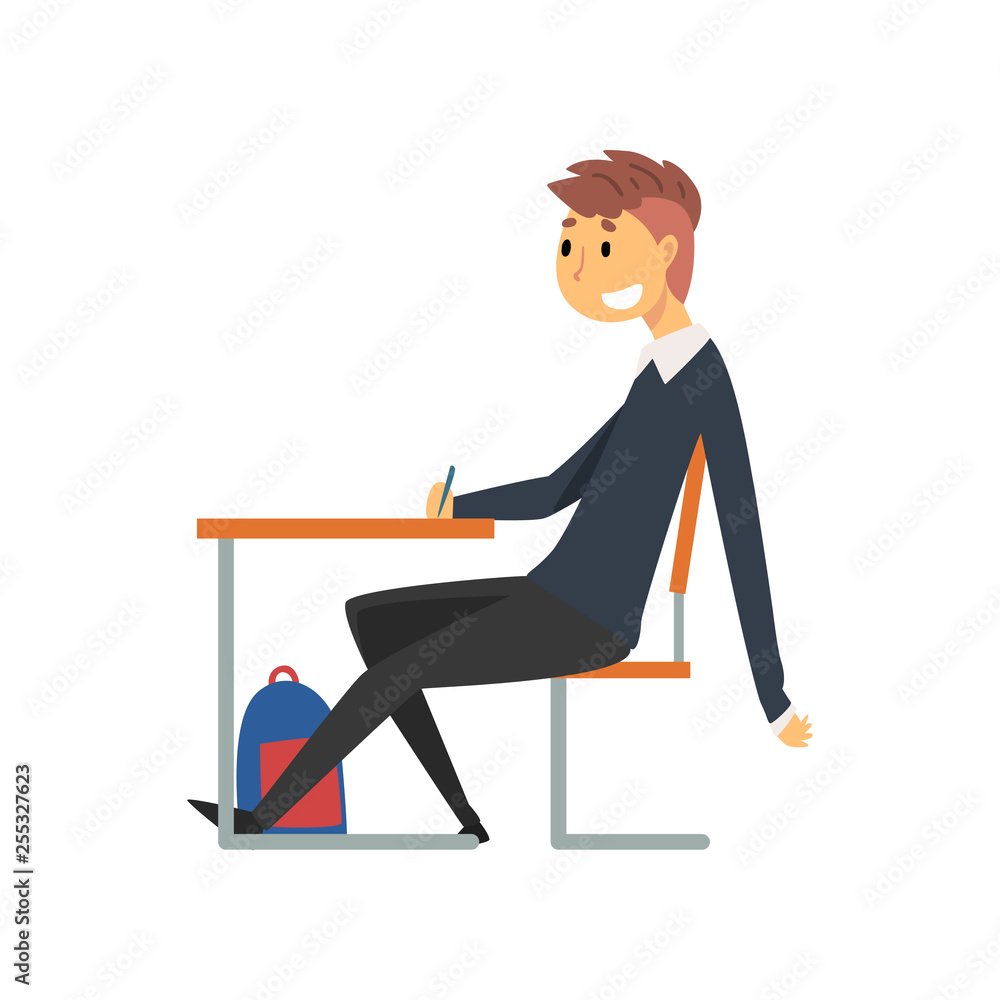 Male Student Sitting and Writing at Desk in Classroom, Side View ...
