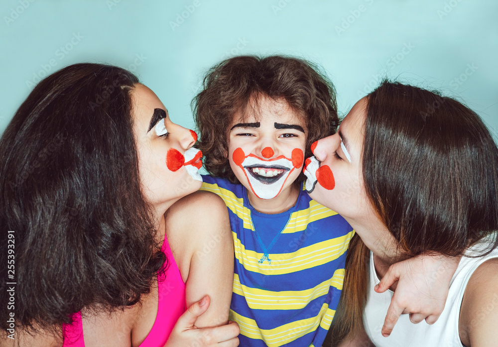 Two teen sisters and a little brother in the role of clowns posing in ...