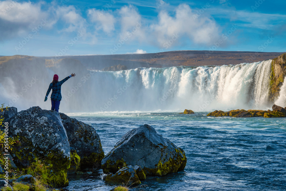 A tourist enjoy viewing at Godafoss the huge waterfalls. One of most ...