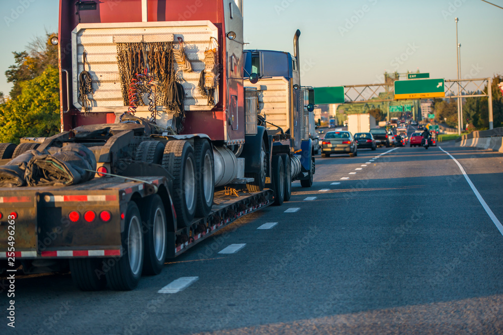 Big rig semi truck transporting another semi truck tractor on step down ...