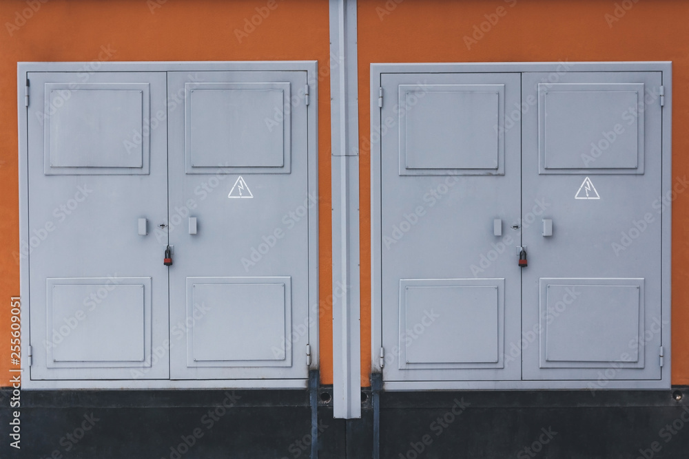 Locked electric panel with hazard sign on the grey door of transformer ...