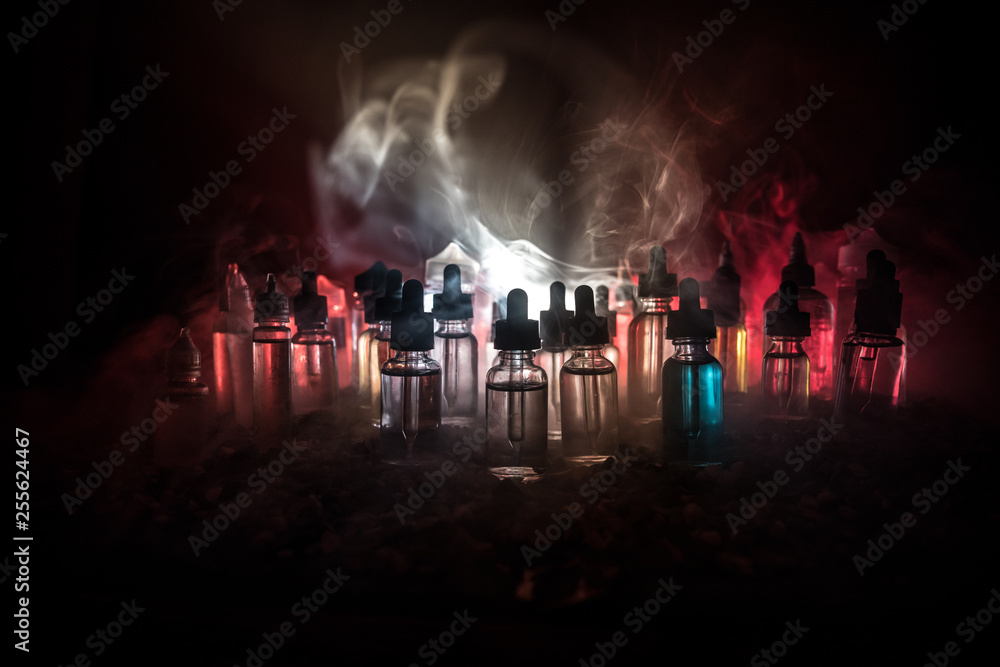 Vape concept. Smoke clouds and vape liquid bottles on dark background ...