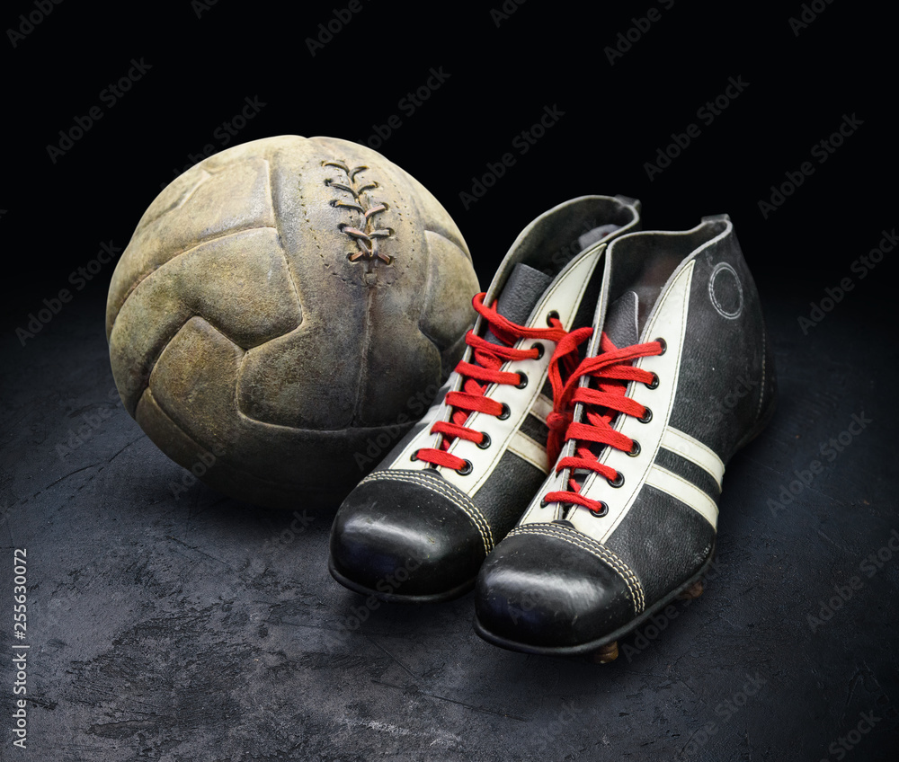 Vintage football ball and boots on black stone background Stock Photo ...