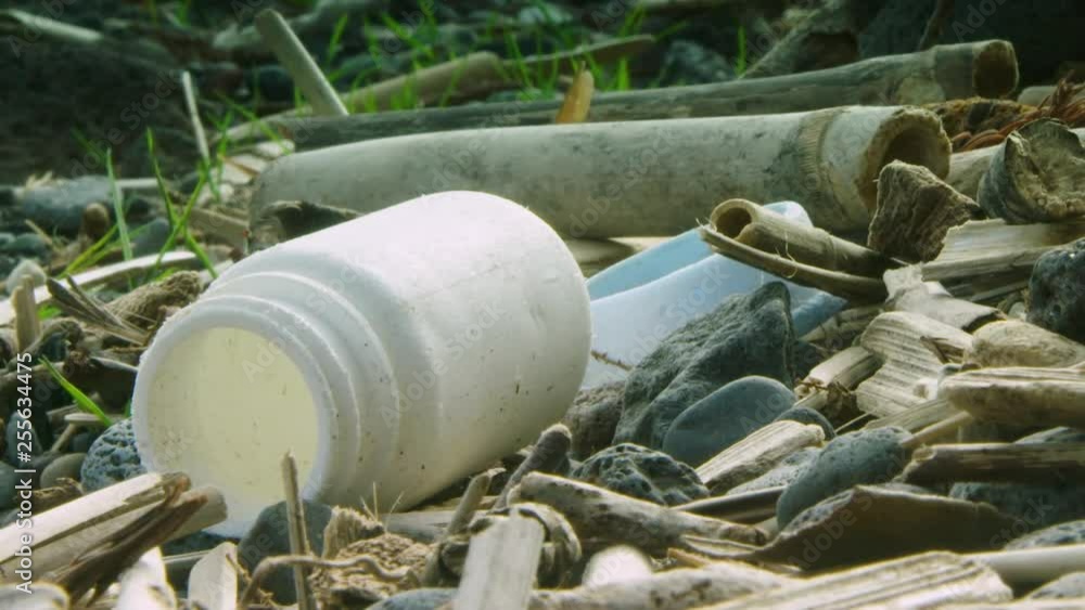 Deep focus shot of a washed up plastic battle lying on a beach ...