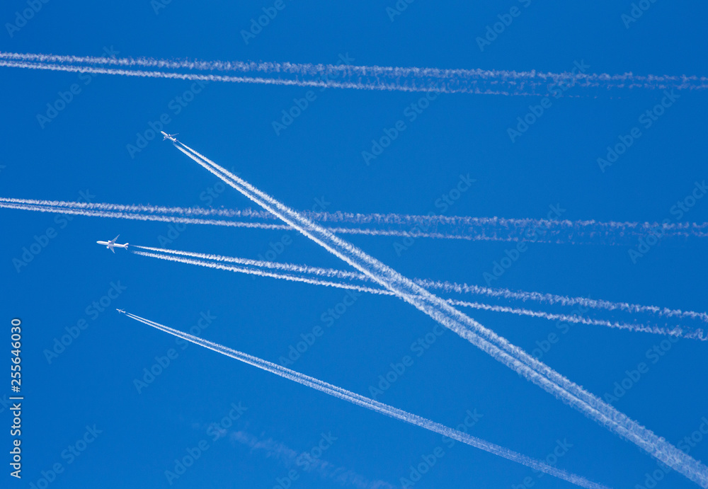 Multiple aircraft in the sky with chemtrails. Conspiracy theory concept ...