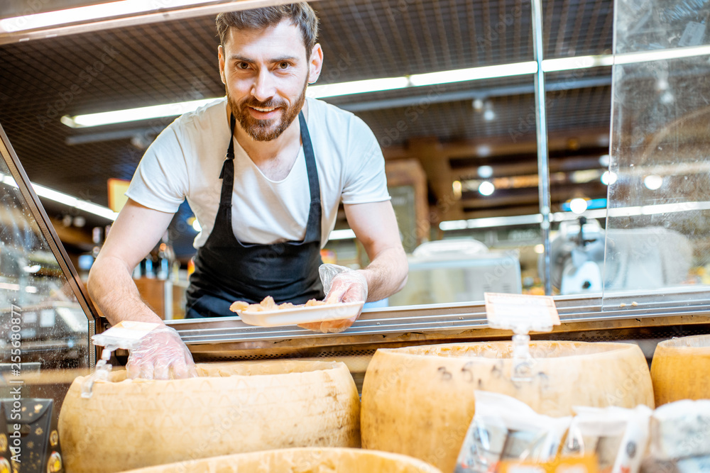 Portrait of a shop worker packing parmesan into the trail, selling ...