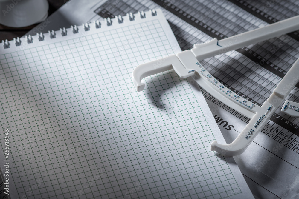Notebook in a cage, body fat caliper to measure body fat, measurement ...
