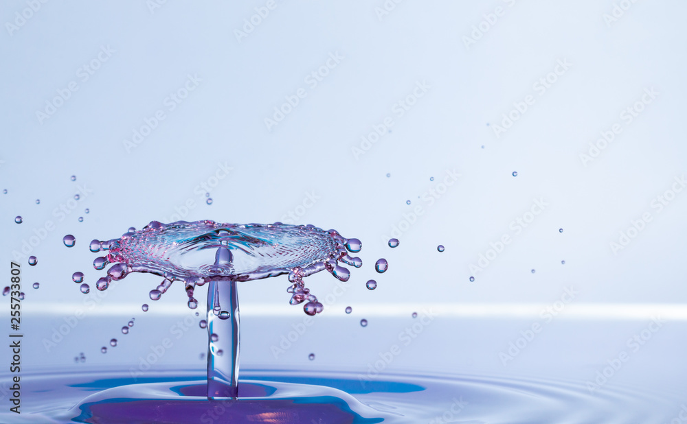 water drop splash impacting a body of water and forming beautiful ...