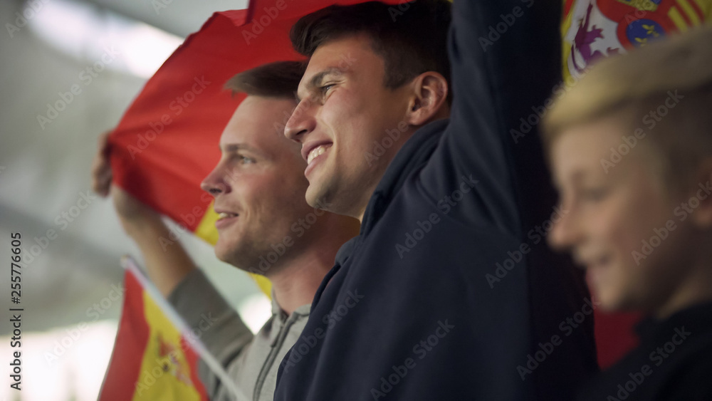Child and adult Spanish football fans waving flag, singing national ...