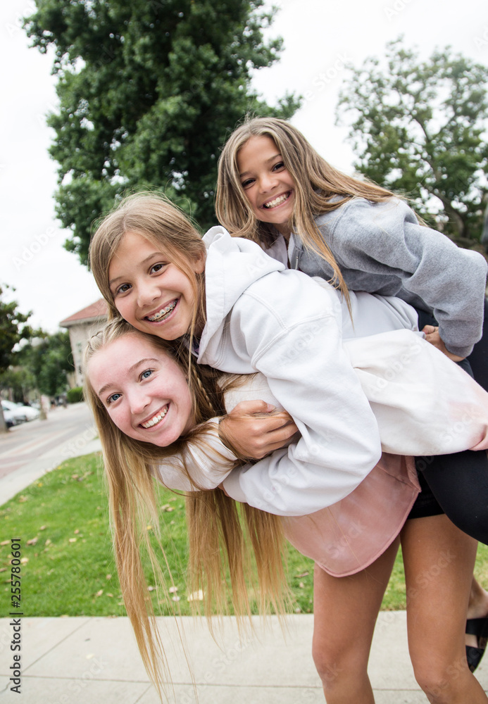 Group of three teen girls having fun and playing together outdoors ...