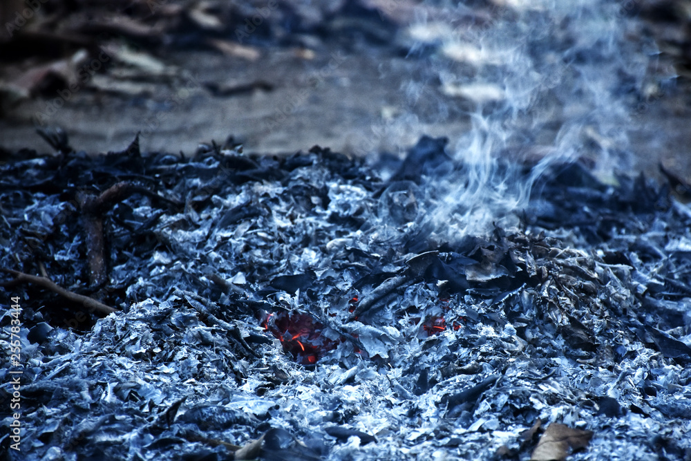 fire brigade is extinguishing with little flames and black ash and ...