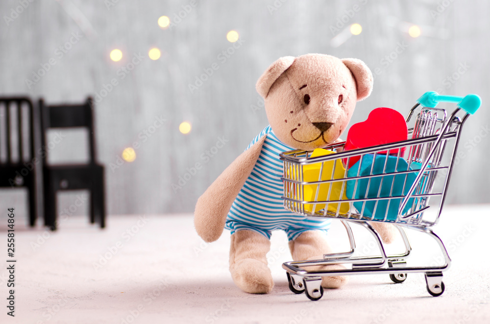 Teddy bear looking at shopping cart with children's wooden toys. Fairy ...