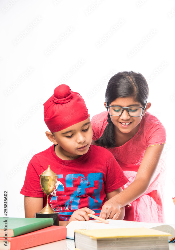 Indian sikh/Punjabi boy and girl studying with books and laptop ...