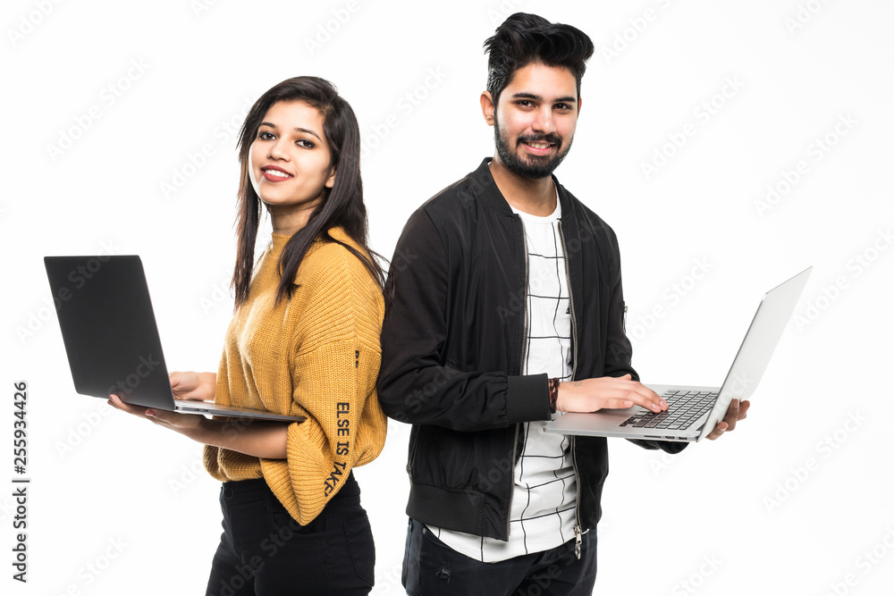 Portrait of a young indian couple holding laptops computer while ...