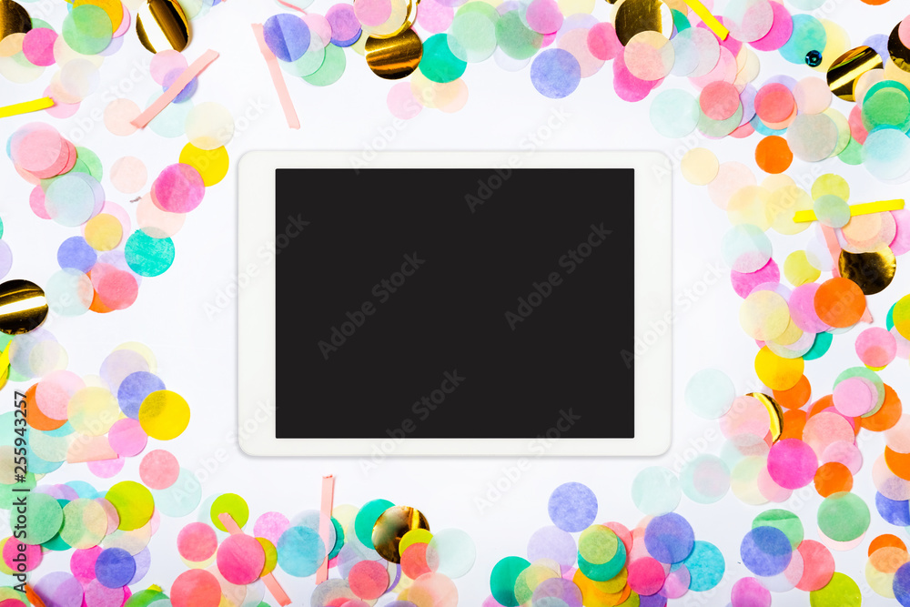 Touchpad with blank screen on colorful confetti background. Color party ...