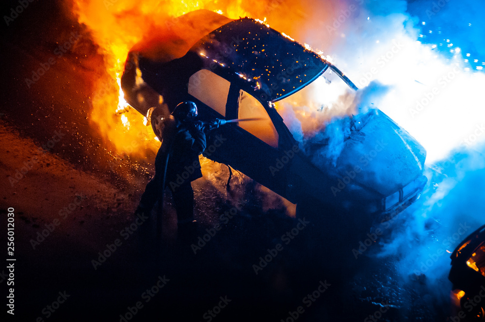 burning car is a flame. Firefighters extinguish the fire. Stock Photo ...
