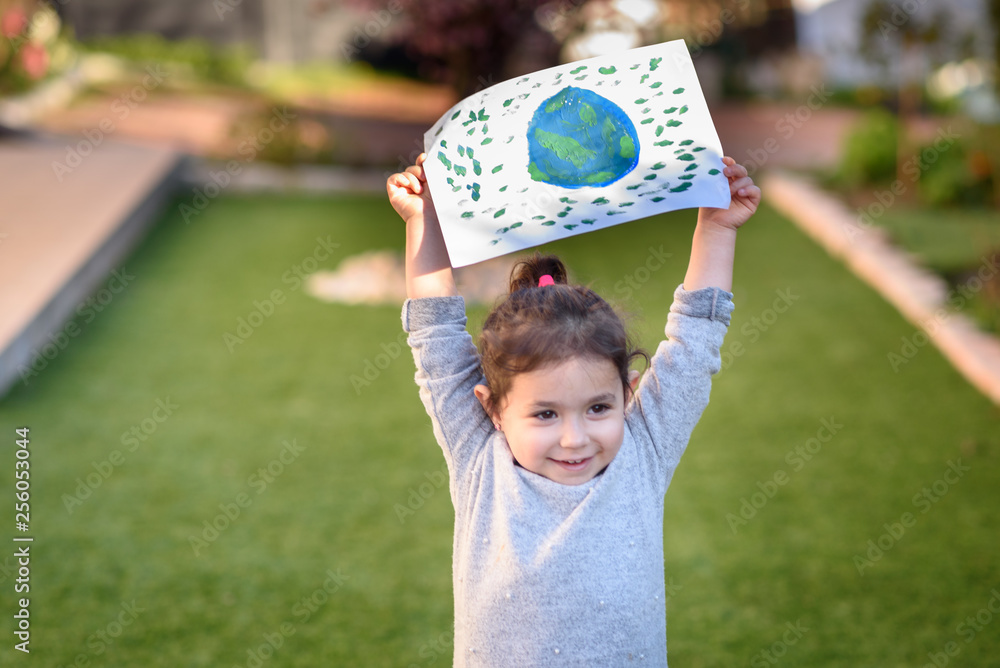 Portrait of the cute little girl holding the drawing earth globe ...