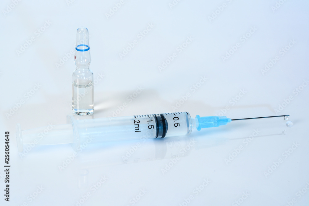 Syringe on a light blue background with medicinal solution. 2 ml ...
