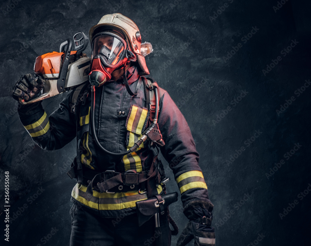 A brave firefighter wearing full protective equipment posing with a ...