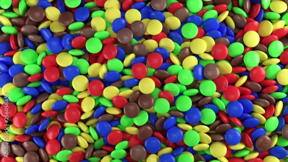 Colorful candy's motion falling down from above and filling the screen ...