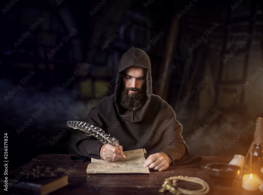 Medieval monk in robe writes with a goose feather Stock Photo | Adobe Stock