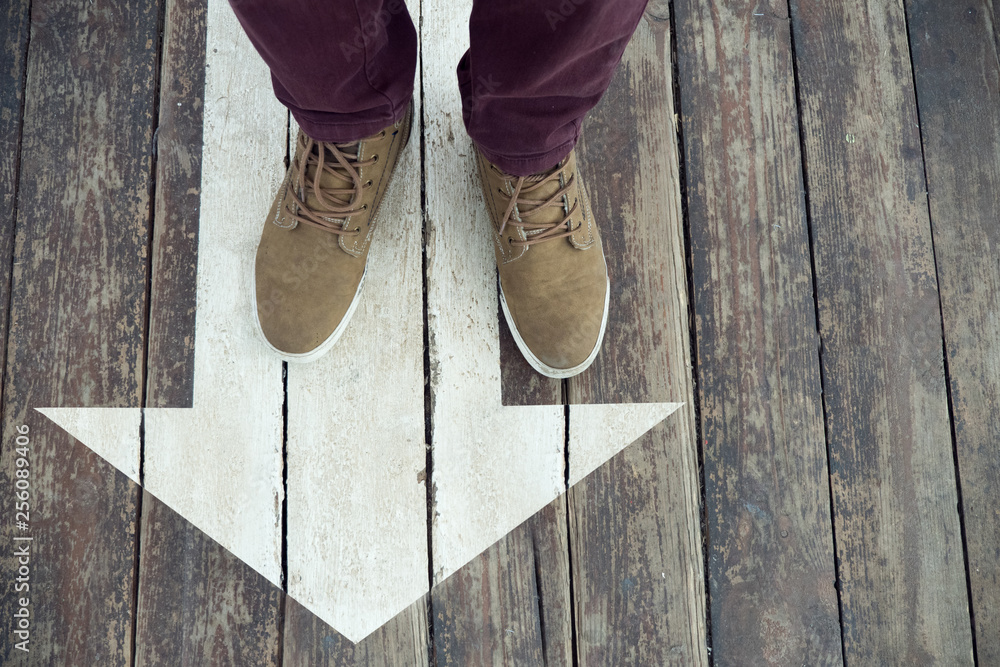 White arrow sign with feet on it. Direction guidline. Following the ...