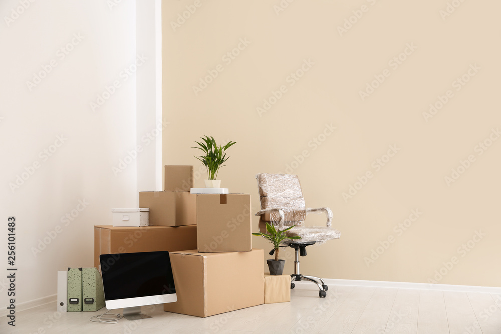 Moving boxes and furniture in new office. Space for text Stock Photo ...