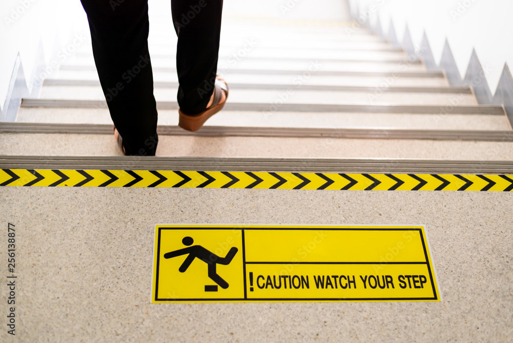 Yellow sign caution warning sign mind the step on floor at staircase in ...