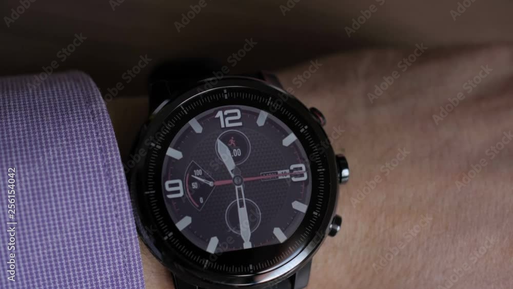 Businessman checks the time on a smartwatch. Close-up. Hands of guy ...