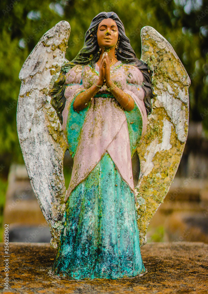 A aged alabaster winged angel grave statue on a grave. The alabaster ...