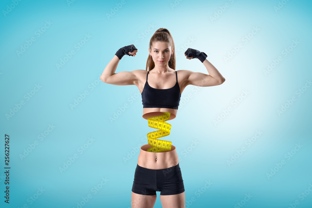 Young fit woman in short black gym top and shorts, in double bicep pose ...