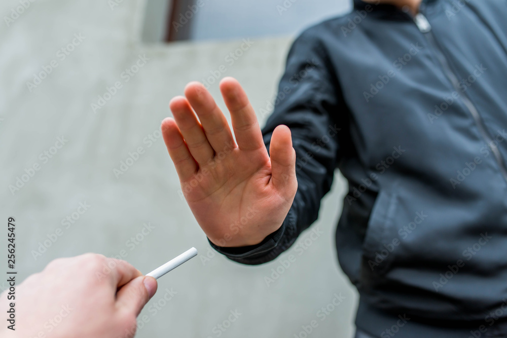 Teenage boy refusing a cigarette, conceptual image of nicotine ...