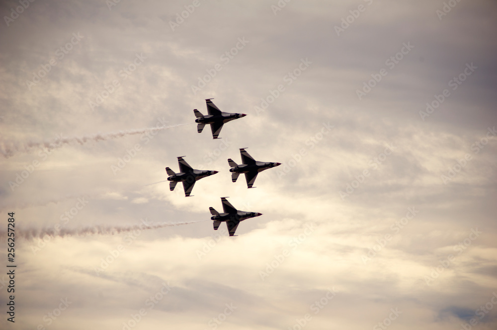 Low angle view of fighter planes flying in cloudy sky during airshow ...