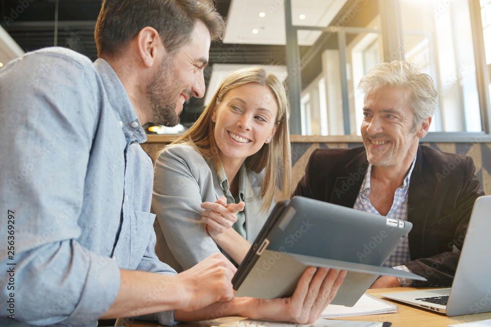 Smiling sales team working through presentation with manager Stock ...