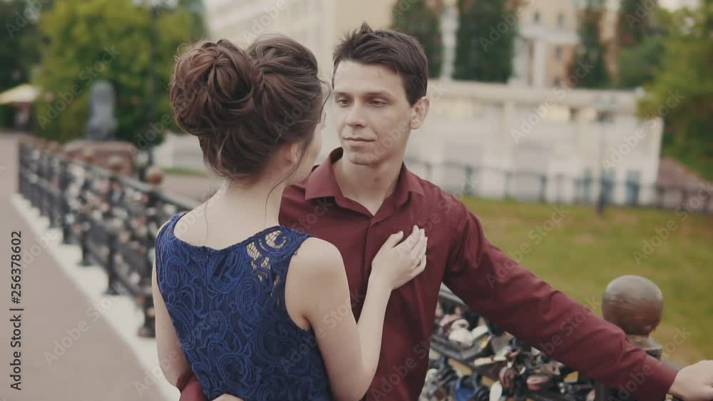 Young couple embrace each other on city street. Handsome man and woman ...