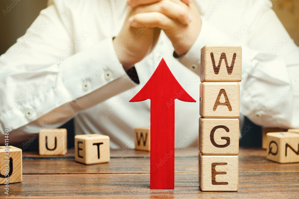 Red arrow up near wooden blocks with the word Wage and a businessman ...