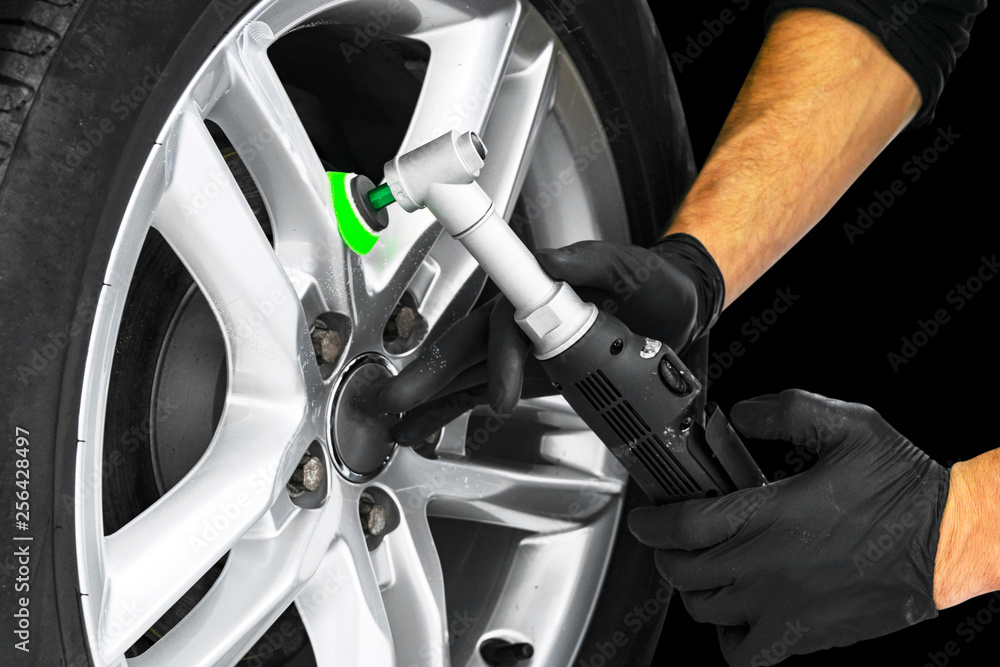 Car polish wax worker hands polishing car wheel. Buffing and polishing ...