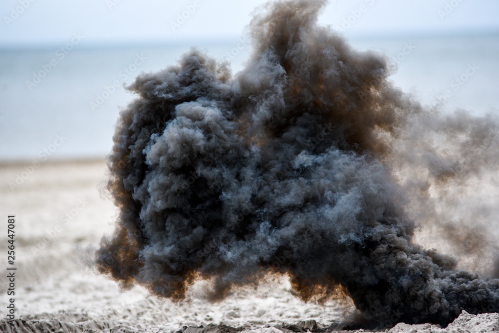 Explosion on the beach, billowing black smoke.. Stock Photo | Adobe Stock