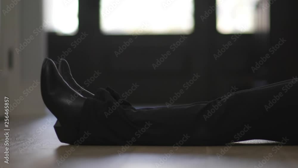 Close up of hands dragging feet into a hallway and then dropping them ...