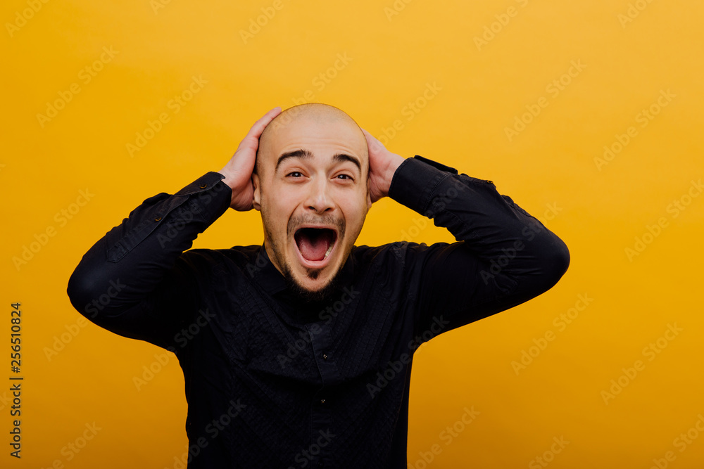 bald man, scared scream, isolated yellow background, black shirt, copy ...