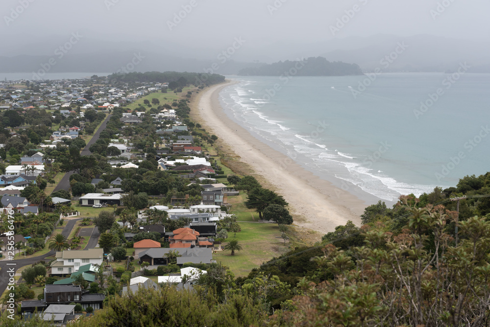 Elevated view of Pauanui township and beach on a rainy day viewed from ...