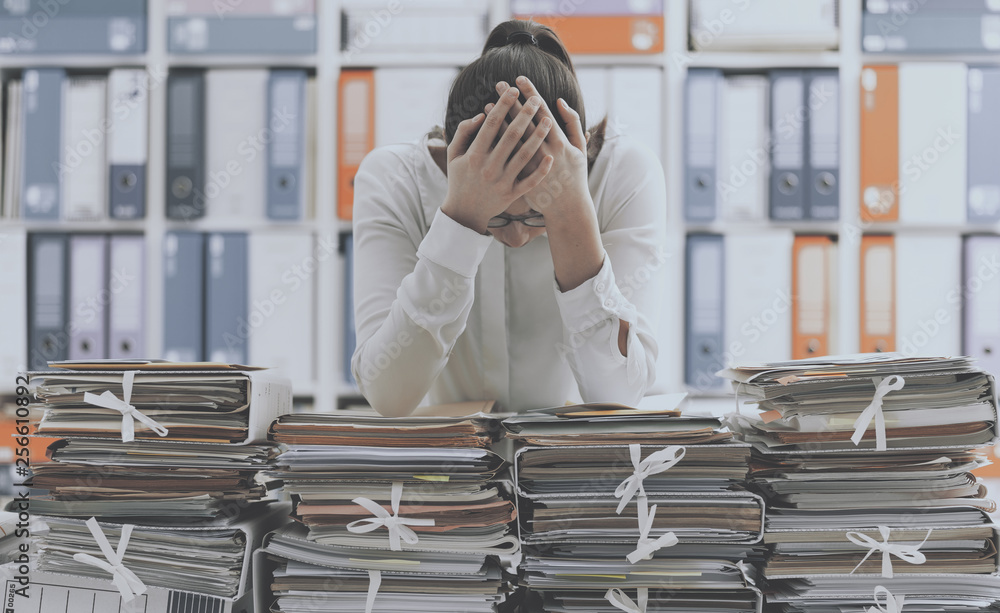 Sad young office worker overloaded with work Stock Photo | Adobe Stock