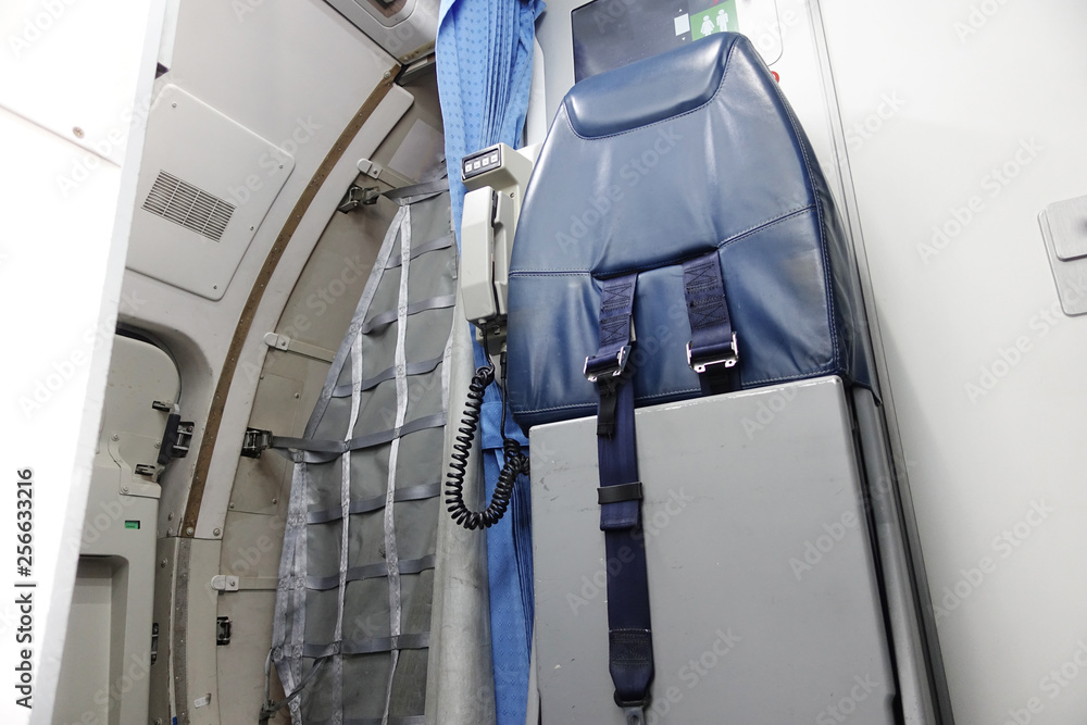 Cabin crew seat in a small aircraft and entrance to the back of the ...