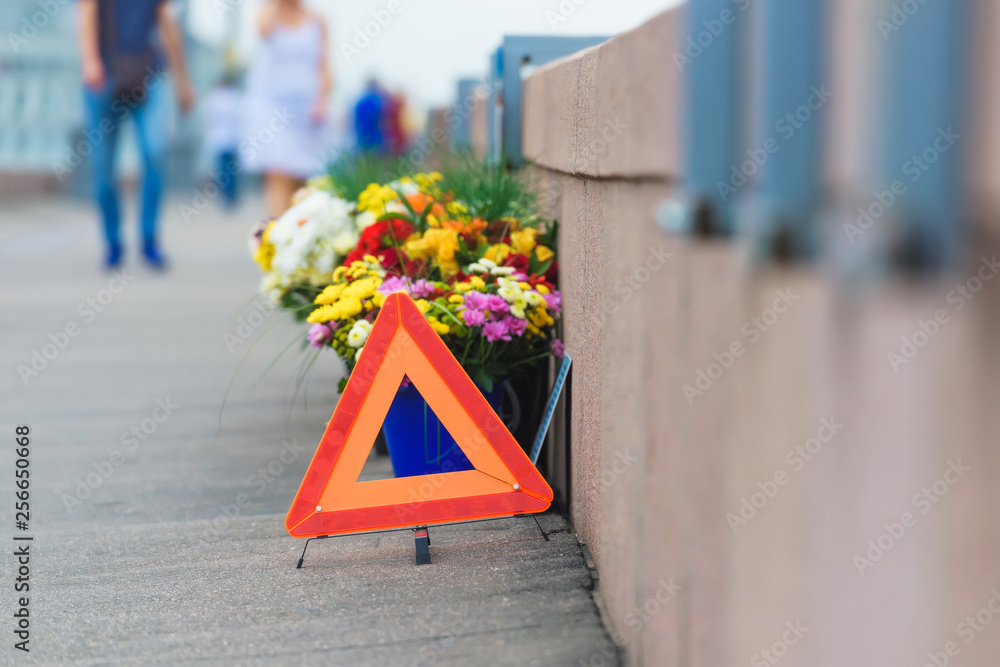 Emergency plastic sign in the form of a red triangle. Bouquets in ...